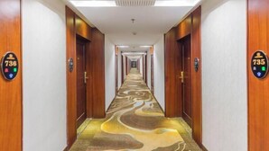 Corredor de hotel com portas de madeira, cada uma identificada com um número e um símbolo.