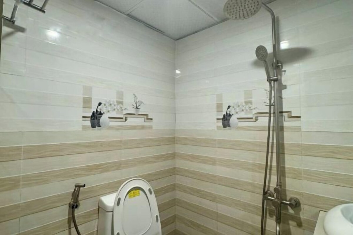 Uma casa de banho moderna com sanita, bidé e chuveiro.