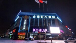 Um hotel com um grande letreiro 'KOHLER', várias bandeiras e sinalização iluminada.