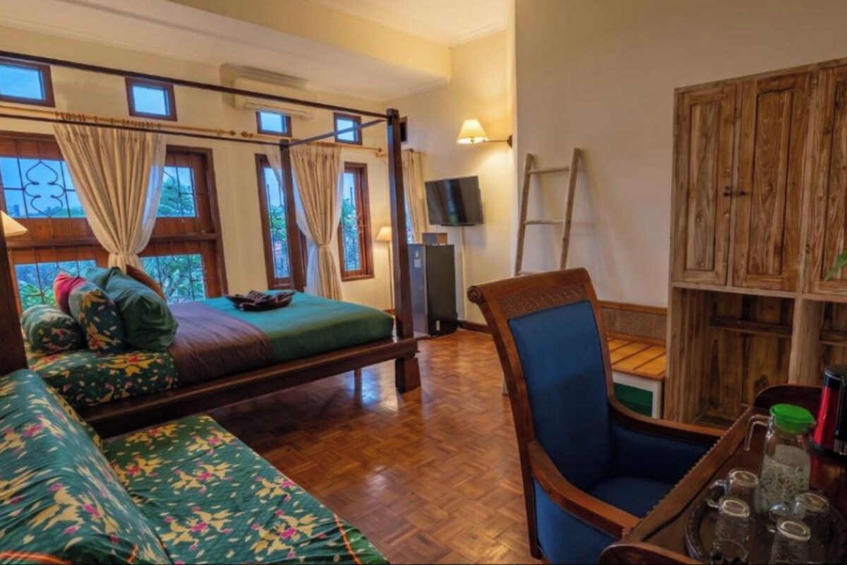 Quarto com cama, sofá, armário de madeira e televisão.