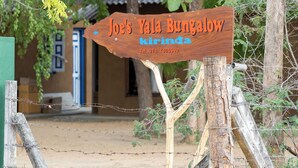 Placa de madeira com o nome Joe's Yala Bungalow em Kirinda e um número de contacto.