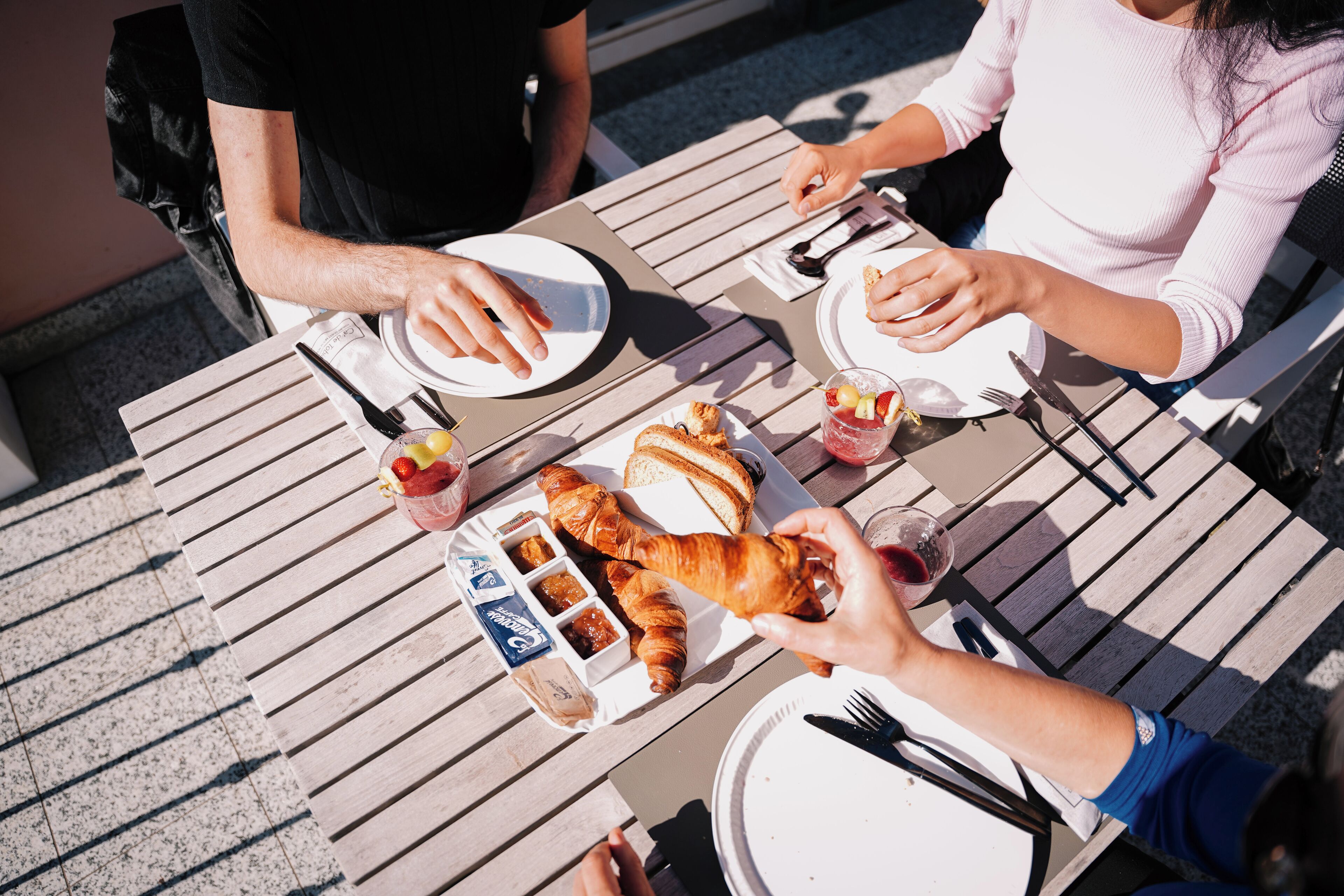 Uma mesa com pratos, croissants e uma bebida.
