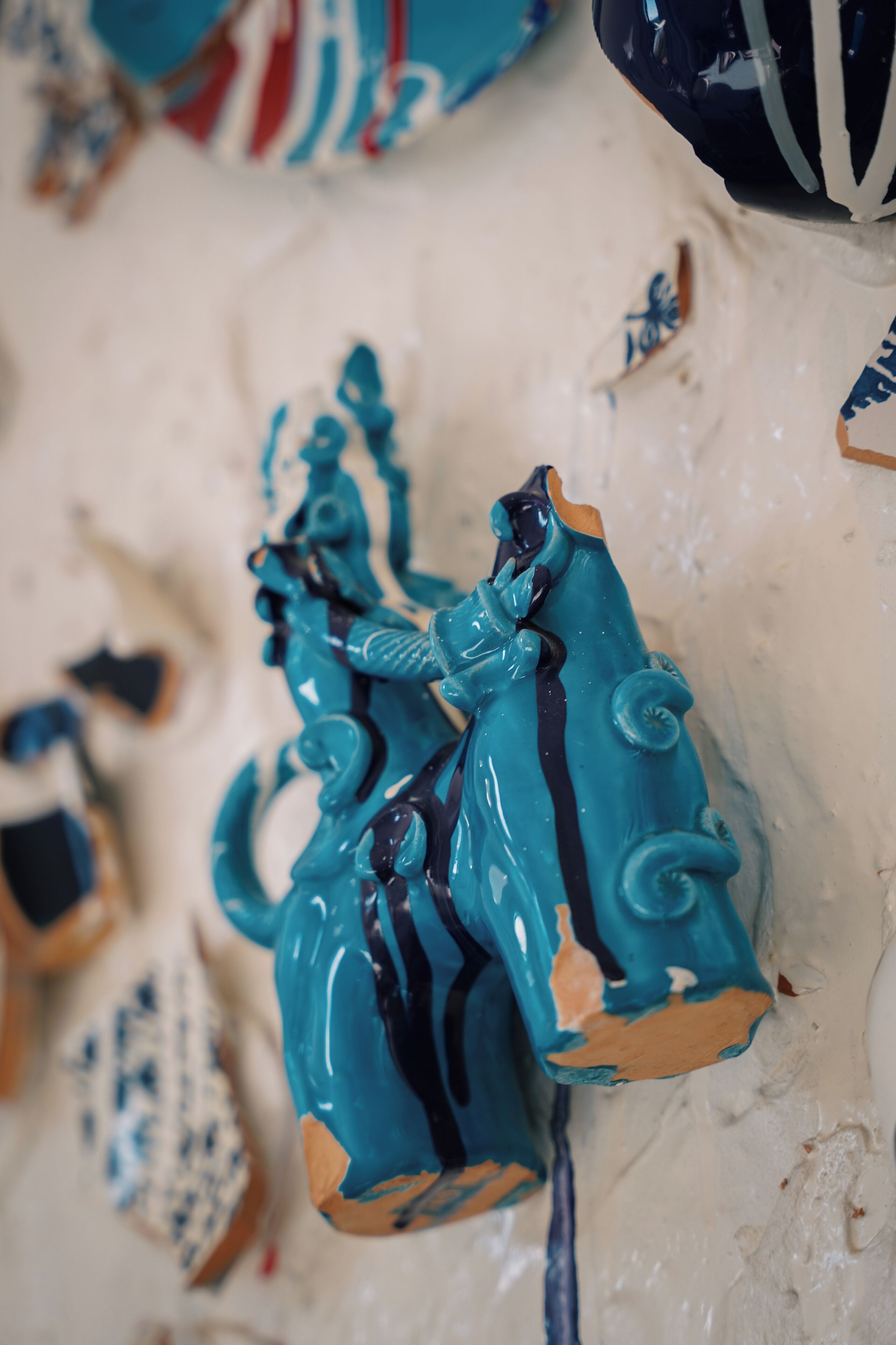 Close-up de uma escultura azul e preta com detalhes e texturas complexas.