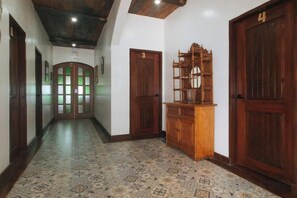 Um corredor com portas de madeira, piso estampado e um armário de madeira.