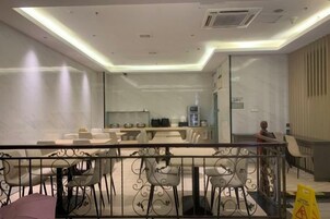 Uma área de refeições moderna com divisória de vidro, guarda-corpo metálico e mobiliário contemporâneo.