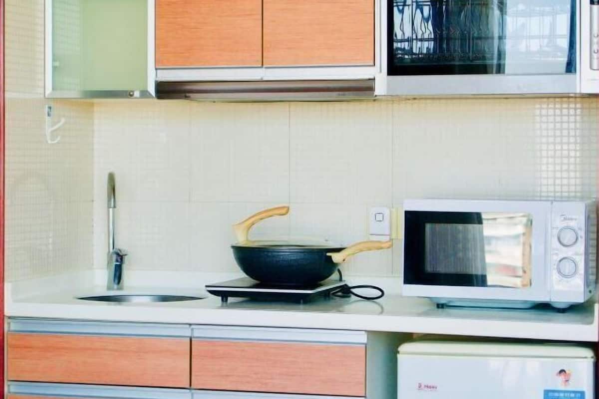 Uma cozinha com micro-ondas, fogão e pia.