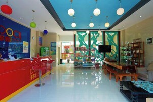 Espaço interno bem iluminado com balcão de recepção, área de estar e estantes de exposição.