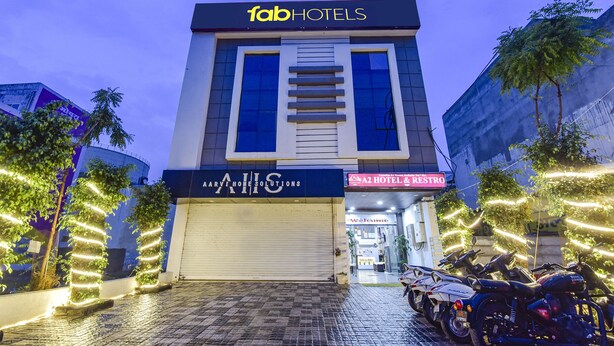Um edifício com uma placa indicando 'fab hotels' e 'A2 Hotel & Restro'.