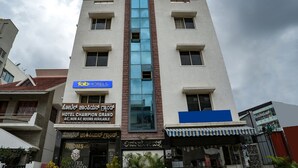 Um hotel com fachada moderna, várias varandas e uma placa chamativa com a inscrição 'Hotel Champion Grand'.