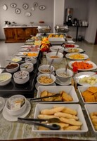 Um buffet com diversos alimentos e utensílios.