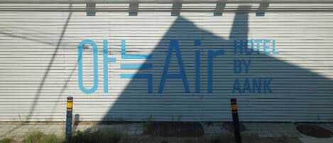 Placa de hotel com o nome 'Air by AANK' sobre um fundo branco.