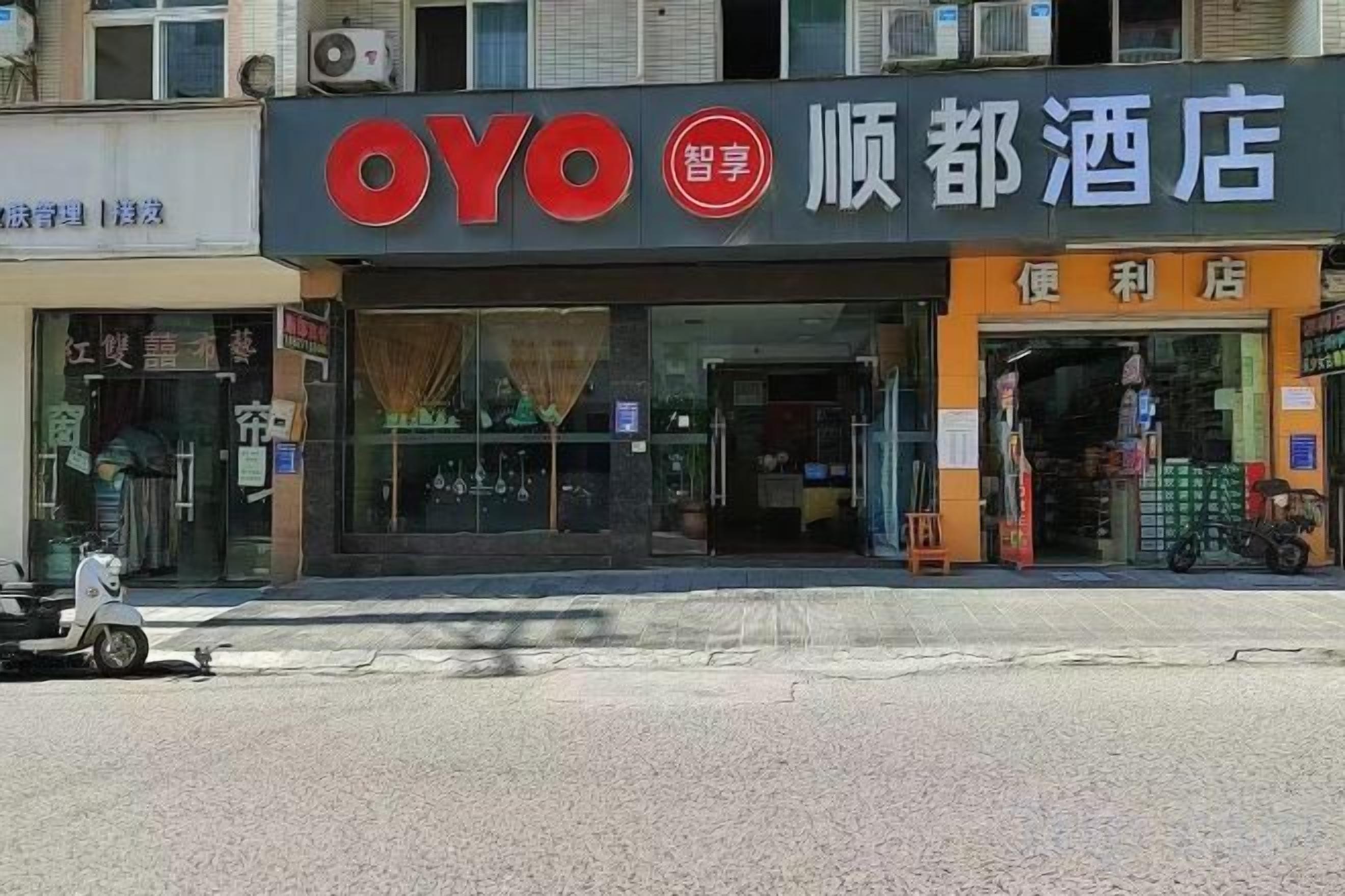 Hotel com destaque para o logotipo OYO, fachada com janelas de vidro e entrada visível.