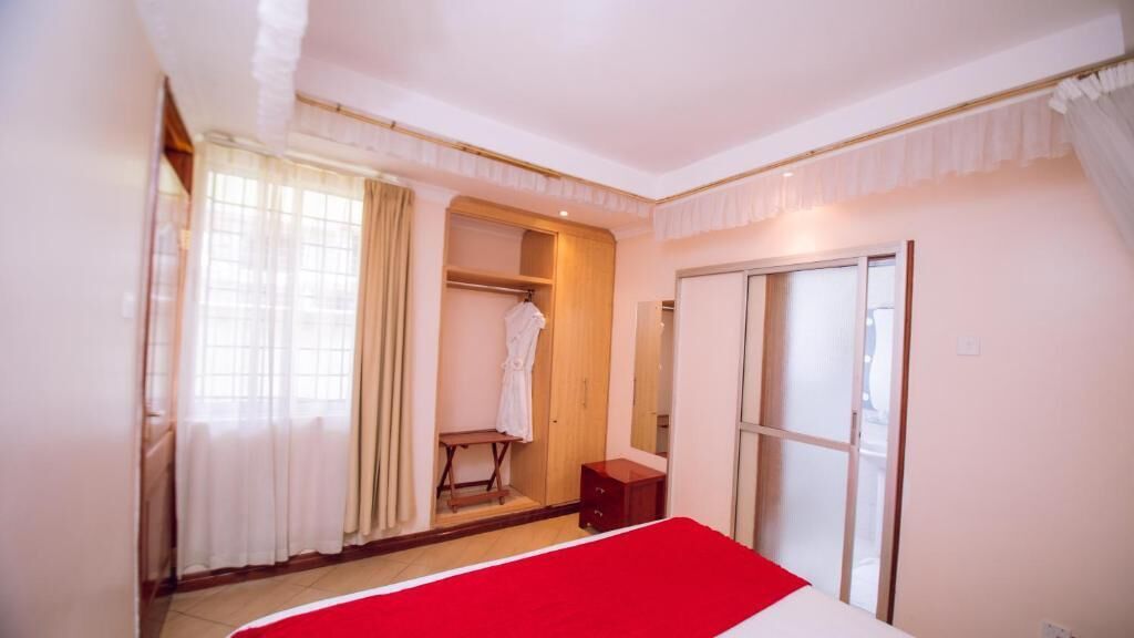 Quarto com cama, guarda-roupa, espelho e porta deslizante.