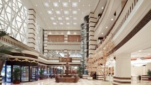 Um hall amplo com uma fonte central, vários andares e um design arquitetônico moderno.