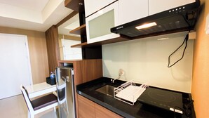 Uma cozinha moderna com eletrodomésticos de aço inoxidável, um fogão por indução preto e armários de madeira.