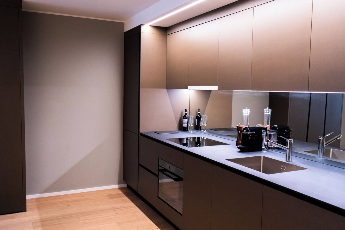 Uma cozinha moderna com uma ilha grande, eletrodomésticos de aço inoxidável e um design elegante.