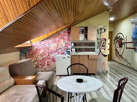 Cozinha compacta com armários de madeira, geladeira branca e bancada pequena.