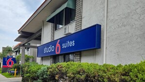 Um edifício com uma placa indicando 'Studio 6 Suites'.