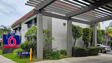 Um edifício com uma placa indicando 'Studio 6 Suites' e uma placa com a palavra 'ENTRE'.