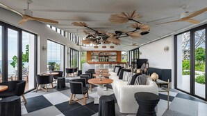 Um interior moderno com piso xadrez, área de bar e grandes janelas com vista para o exterior.
