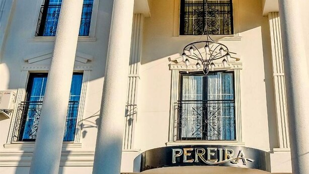 Um edifício com arquitetura clássica, com colunas e uma entrada imponente com o nome 'PEREIRA'.