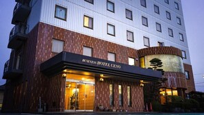 Um hotel para negócios com fachada moderna, entrada imponente e placa com o nome.