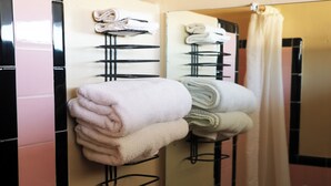 Uma casa de banho com um porta-toalhas com toalhas dobradas.
