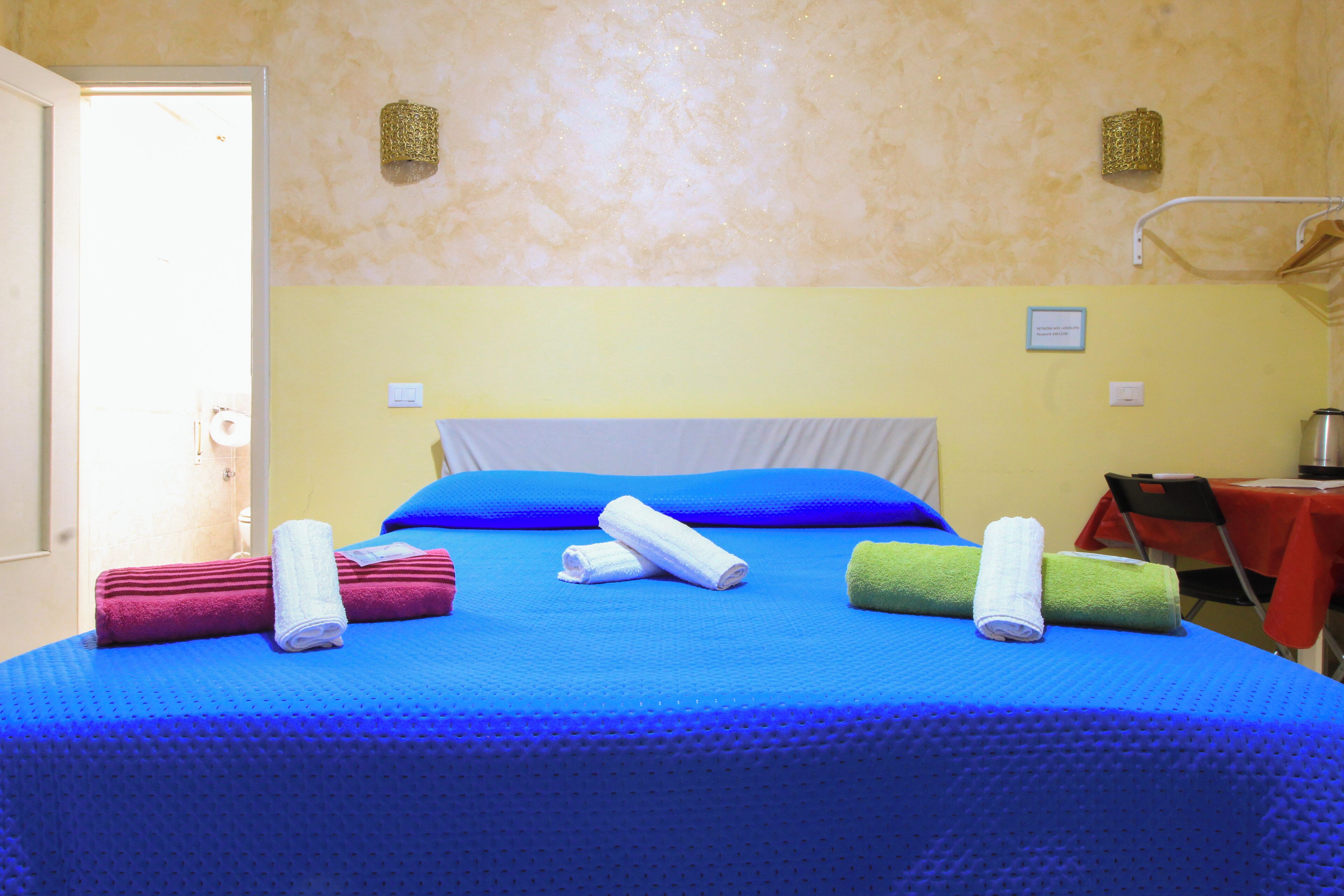 Um quarto com uma cama, uma cadeira e uma mesa.