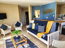 Apartamento família, varanda, vista para o jardim | Área de estar | TV