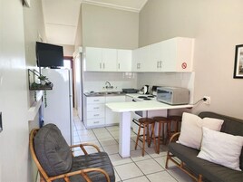 Apartamento básico, vista para o pátio | Cozinha privada | Geladeira grande, micro-ondas, fogão, cooktop
