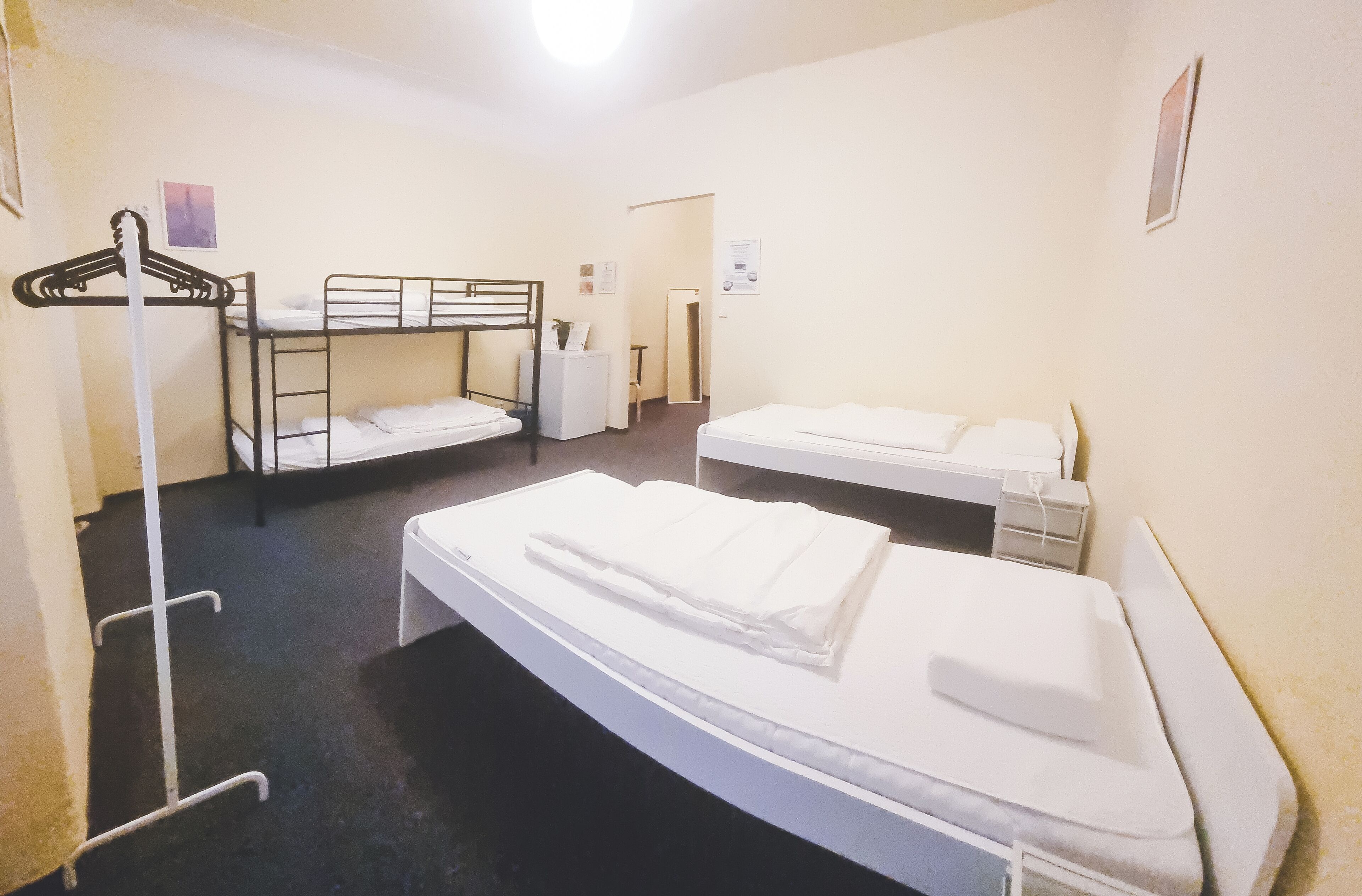 Quarto de dormitório com beliches, escrivaninha e espelho.