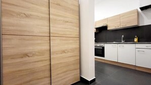 Cozinha moderna com armários de madeira, bancada preta e fogão.