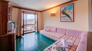 Um quarto acolhedor com um sofá xadrez, um armário de madeira e um cartaz na parede.