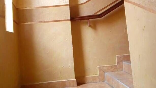 Uma escadaria com corrimão e um patamar, dando acesso a um andar superior.