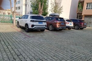 Área de estacionamento pavimentada com quatro SUVs estacionados em linha.