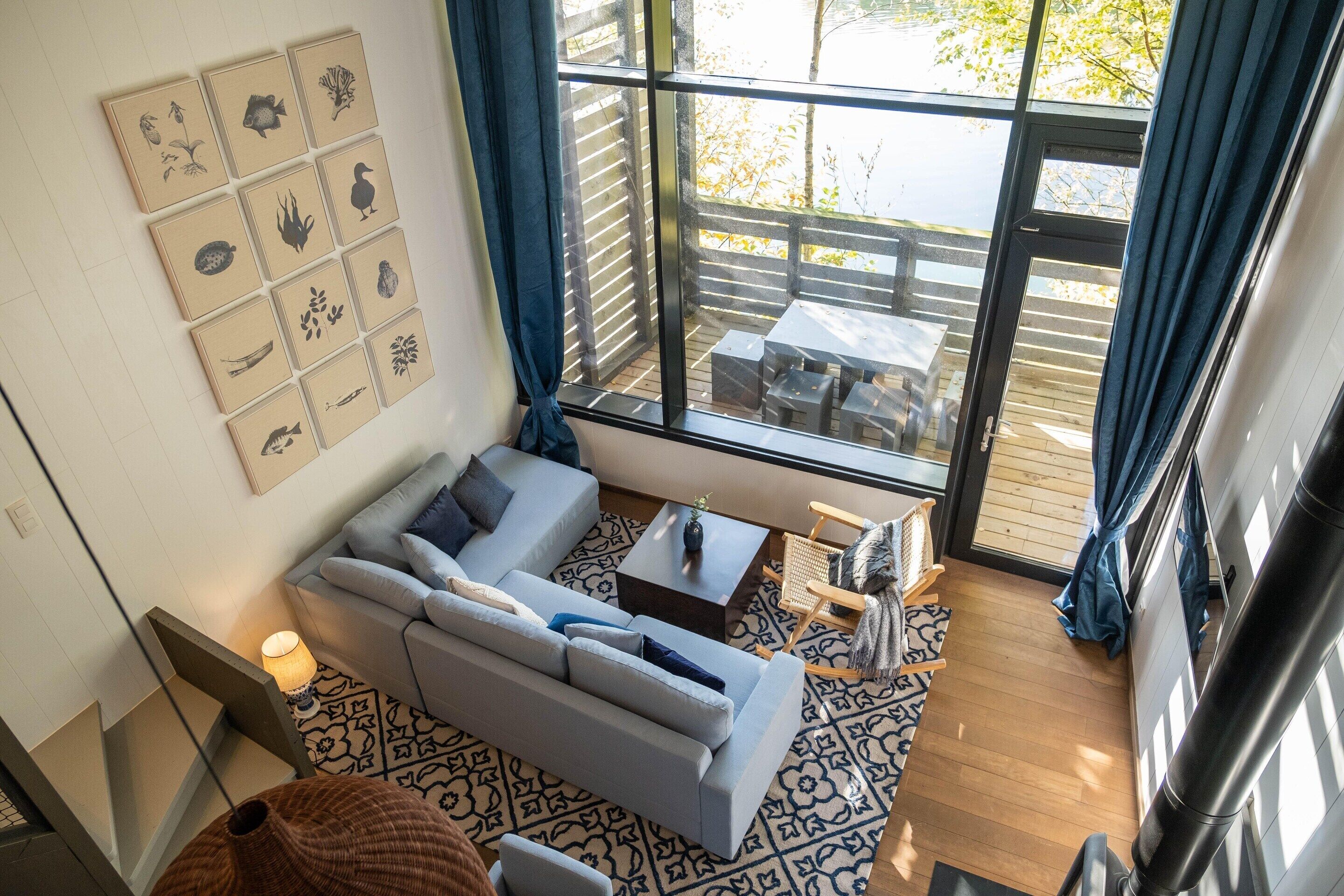 Uma sala de estar moderna com um sofá modular, uma mesa de centro e um tapete estampado.