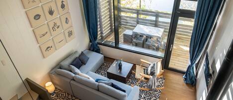 Uma sala de estar moderna com um sofá modular, uma mesa de centro e um tapete estampado.