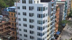 Um edifício de vários andares com design moderno, com uma combinação de varandas e janelas.