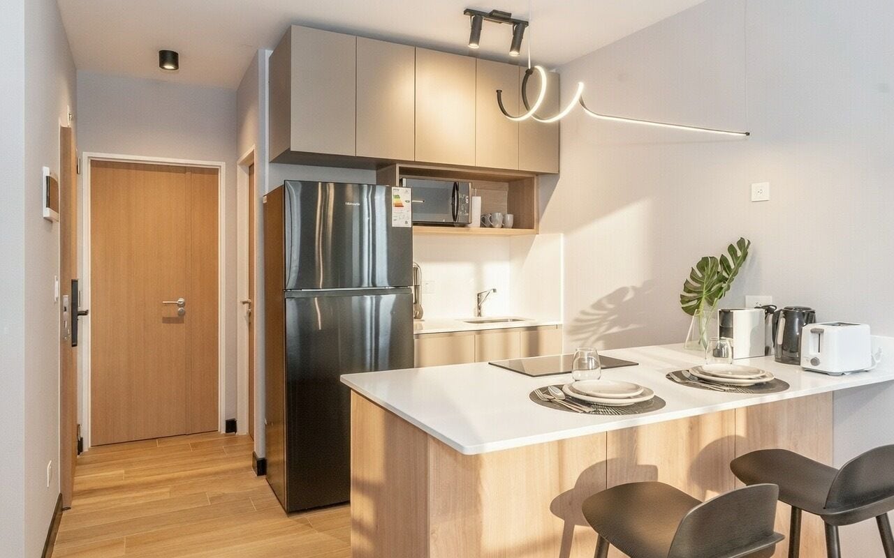 Uma cozinha moderna com ilha integrada, eletrodomésticos de aço inoxidável e design minimalista.