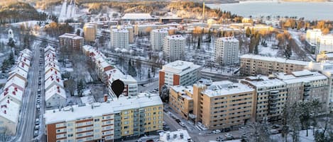 Um complexo de edifícios altos com vários prédios de apartamentos, uma rua central e um corpo d'água ao fundo.