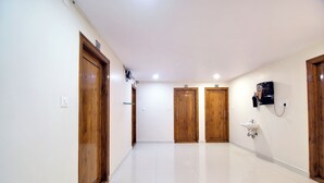 Um corredor com portas de madeira, uma pia e um bebedouro.