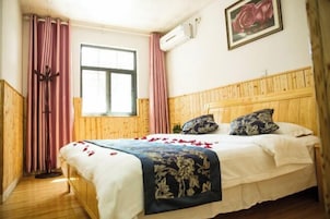 Um quarto com painéis de madeira, uma cama, uma janela com cortinas e um quadro na parede.