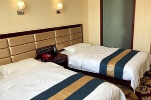 Quarto de hotel com duas camas, cada uma com cabeceira e mesas de cabeceira.