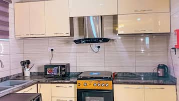 Quarto família, sacada, vista para a cidade | Cozinha privada | Frigobar, micro-ondas, fogão, cooktop