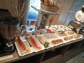 Buffet com diversos alimentos e um liquidificador identificado como "SEÇÃO FRIAS".