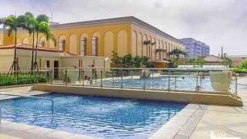 Uma área de piscina com um edifício ao fundo.