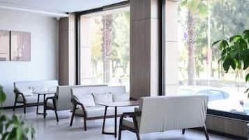Um hall de hotel moderno com área de estar, janelas amplas e vista para o exterior.
