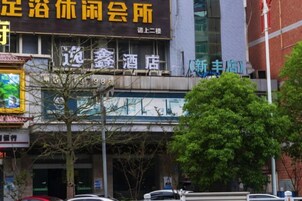 Um hotel com placas indicando 'Hongxin Hotel' e 'Jiafeng Hotel' na fachada.