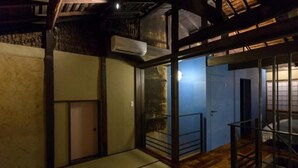 Um quarto japonês tradicional com tatames, portas deslizantes e vista para o exterior.