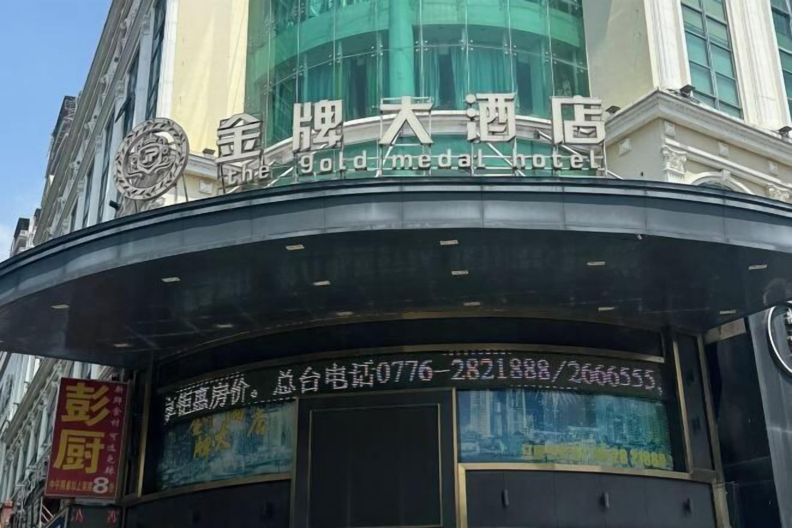 Exterior do Hotel Gold Medal, com o nome e informações de contato exibidos.